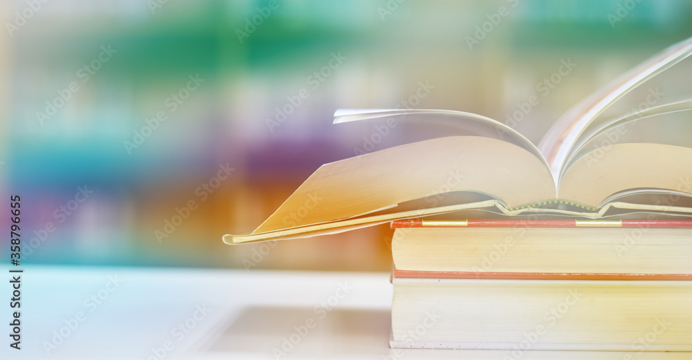 Open Book on wood table and blurred bookshelf in the library, education ...