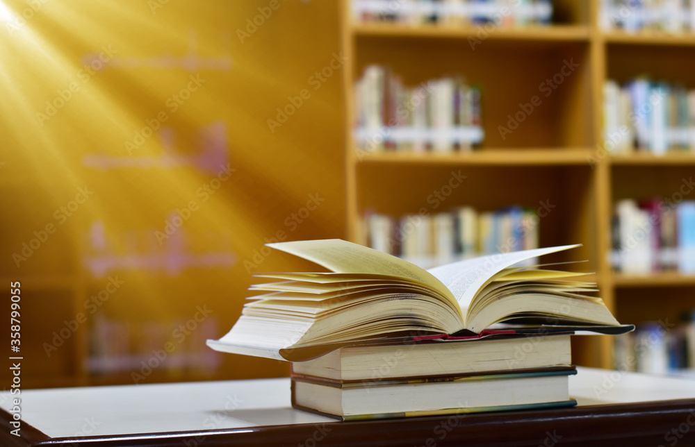 Open Book on wood table and blurred bookshelf in the library, education ...