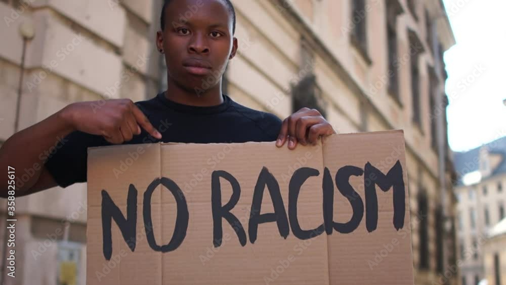 Outdoor portrait of a young black man with a poster in his hands with ...