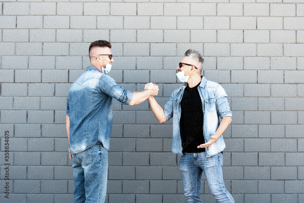 Two friends doing greetings with handshake after coronavirus outbreak ...