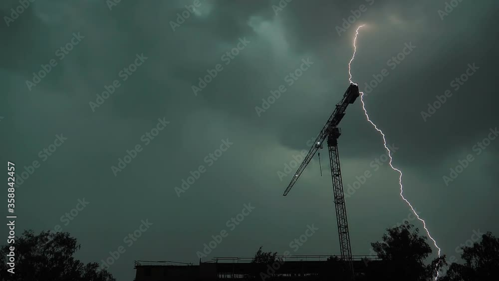 lightning strikes several times in one place, construction crane on ...