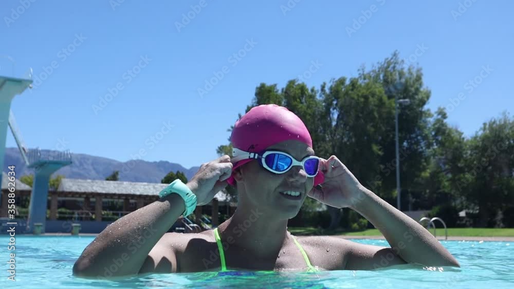 footage of a female swimmer swimming laps in an outdoor pool using the ...