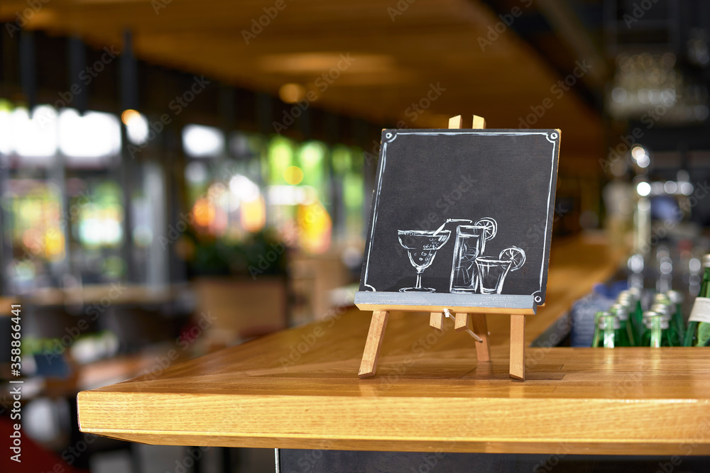 Blackboard menu with easel on wooden table with blur restaurant ...