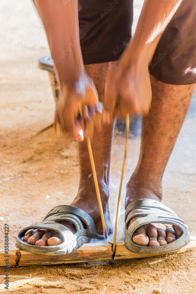 Indigenous man making fire in his village in Taman Negara national park ...