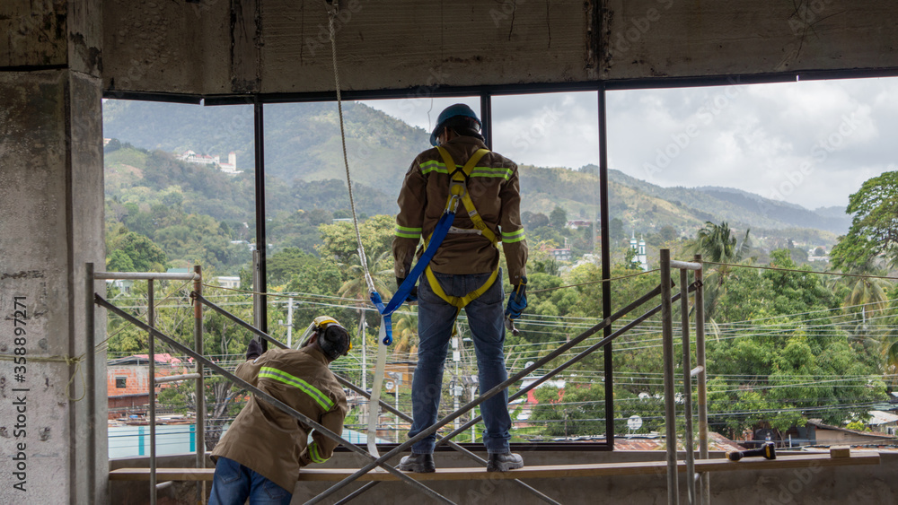 Construction workers repair window to a building. Workers in full ...