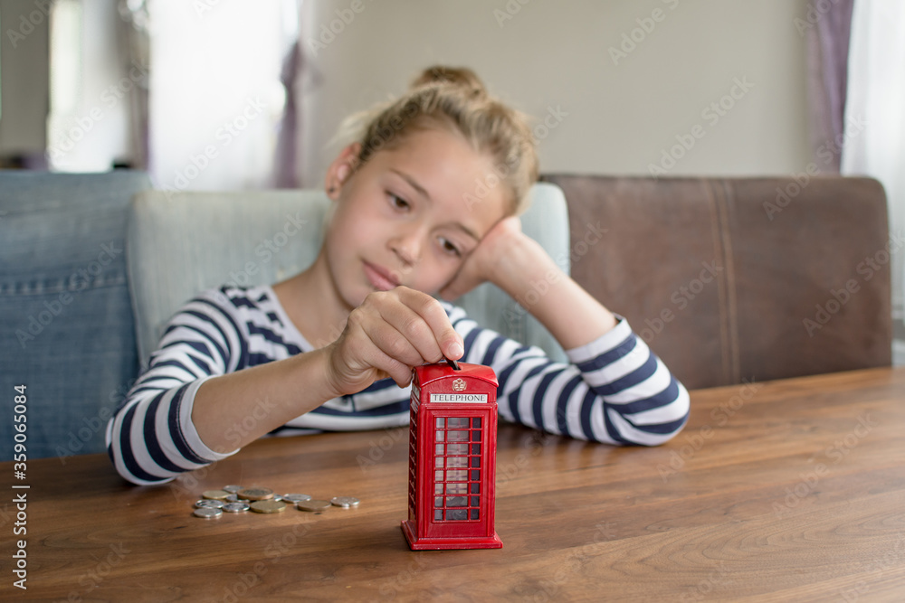 Young girl inserting money to the coin box look like traditional ...