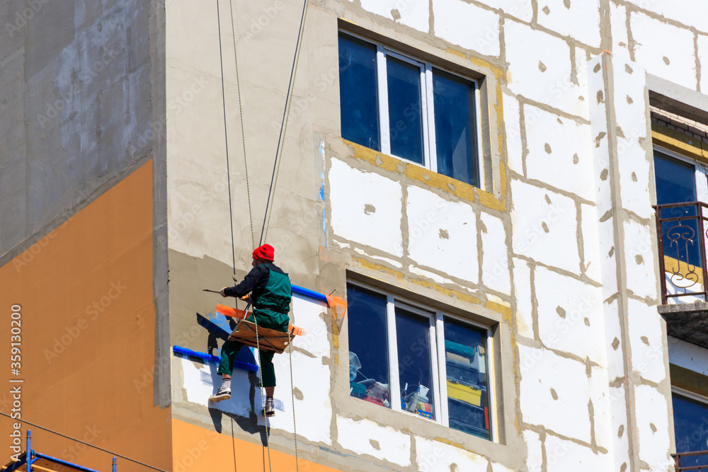Styrofoam insulation of high-rise building. Rope access working ...