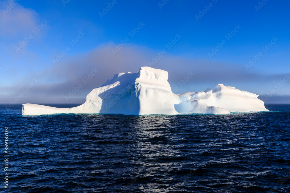 Huge floating iceberg, clearing mist, a symbol of global warming in a ...
