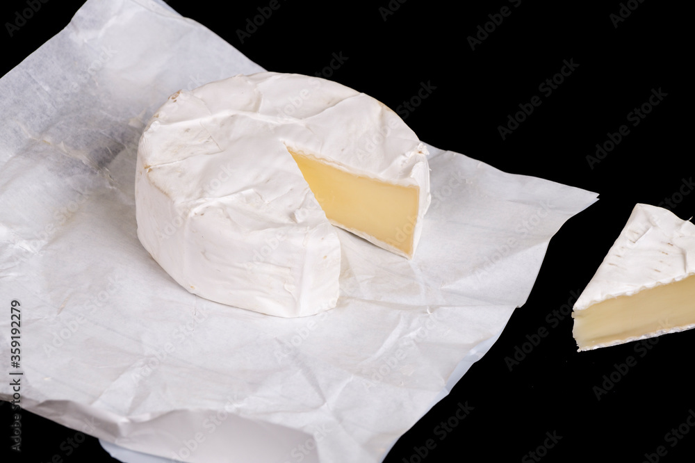 pieces of soft cheese Camembert on dark blackbackground. Delicious ...