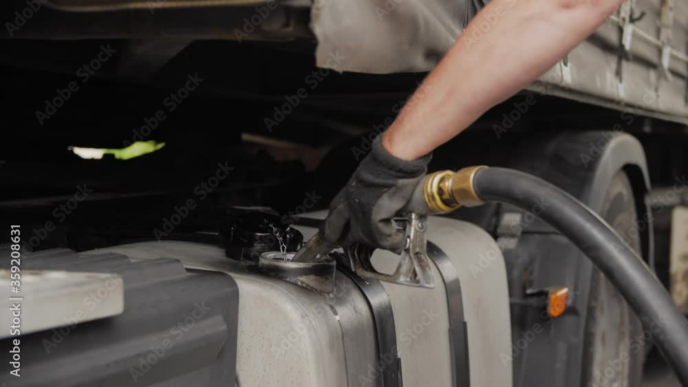 Filling car with gas fuel at station pump. Car transporter truck ...