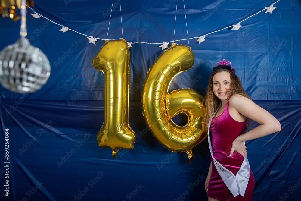 16 year old girl poses for a photo near her birthday party decorations ...