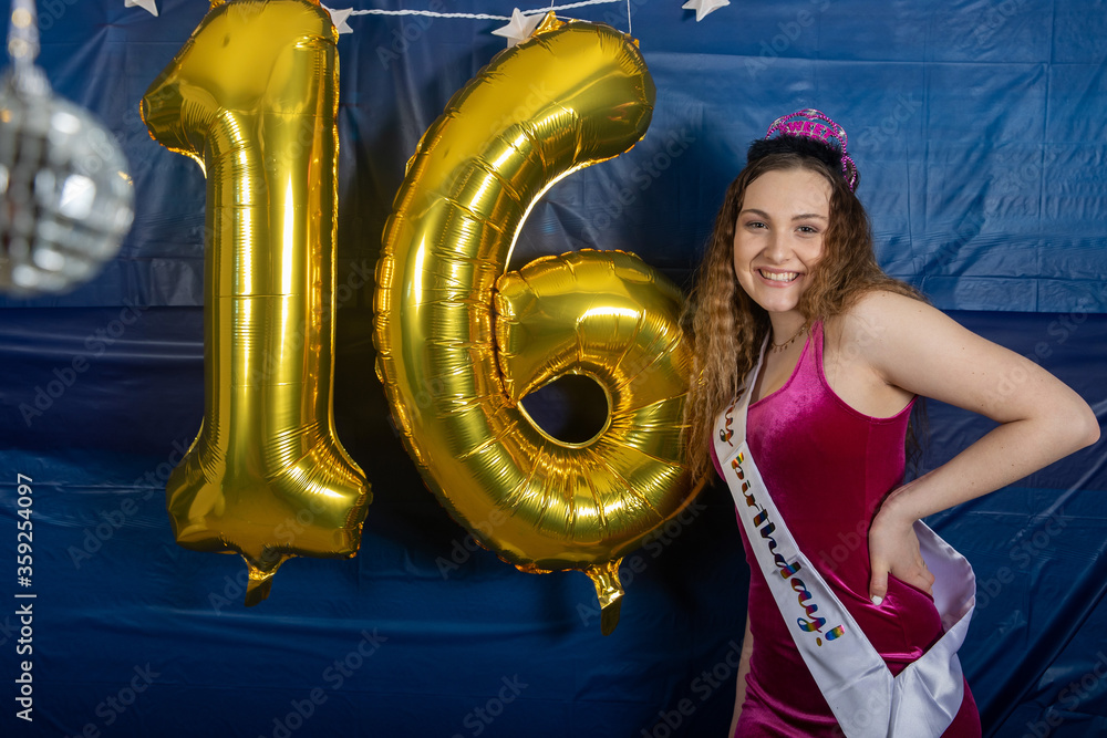 16 year old girl poses for a photo near her birthday party decorations ...