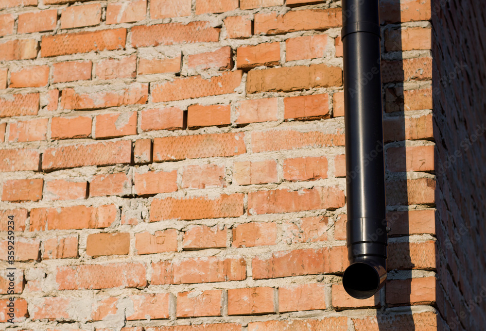 Detail of brick wall,, exterior corner of building with new drainpipe ...