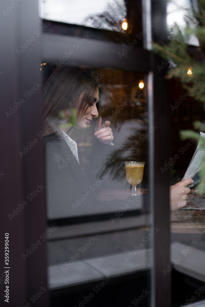 Beautiful brunette girl behind the glass, drinking hot drink portrait ...