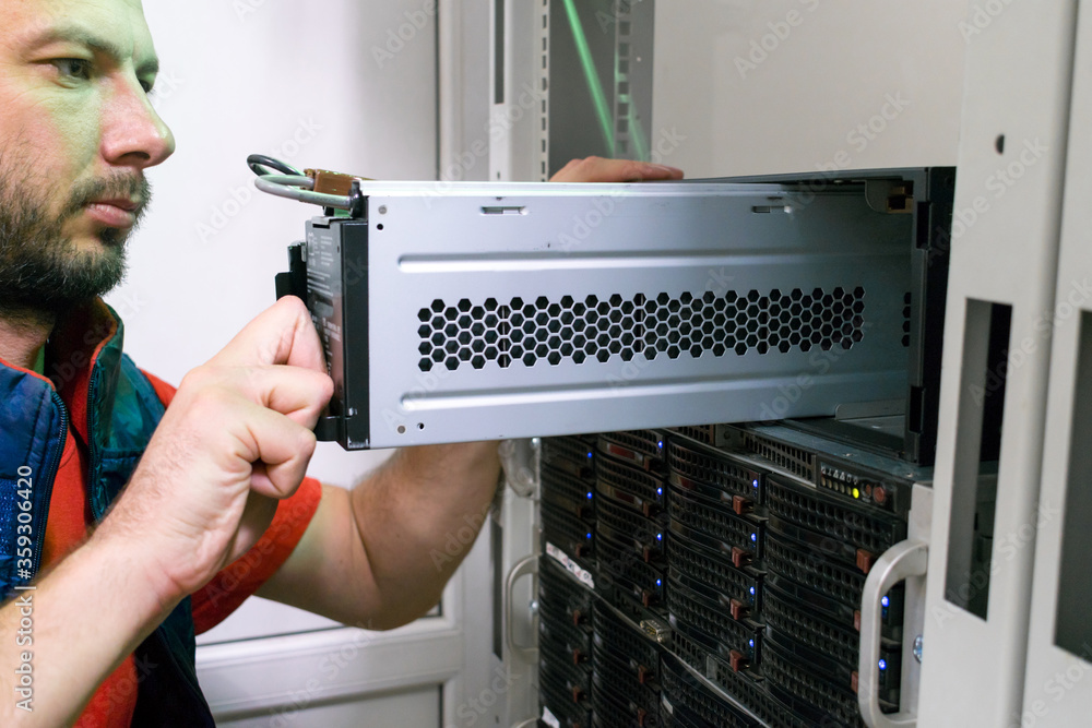The technician installs a new battery pack into the uninterruptible ...