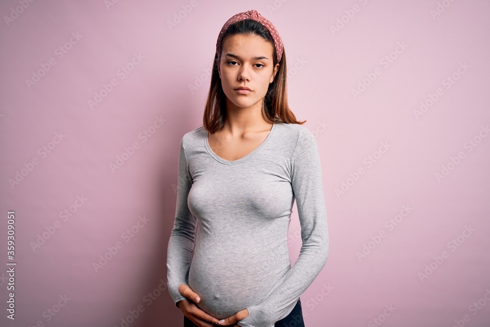 Young beautiful teenager girl pregnant expecting baby over isolated ...