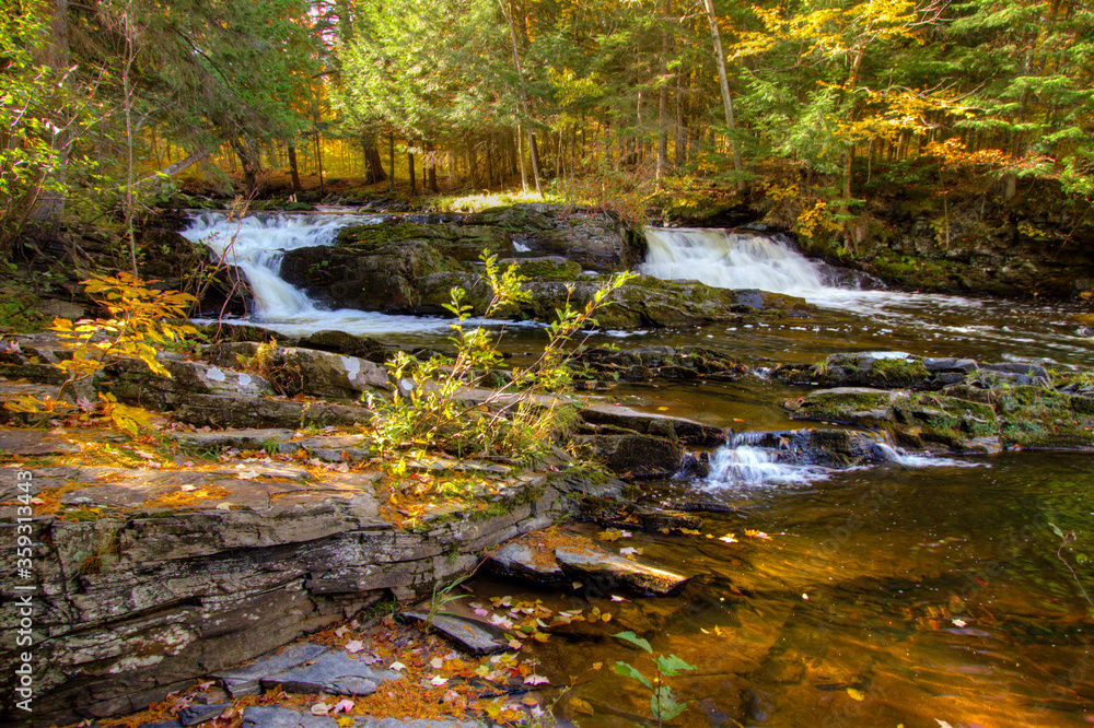 Double Waterfall with fall foliage on the Falls River in the small town ...