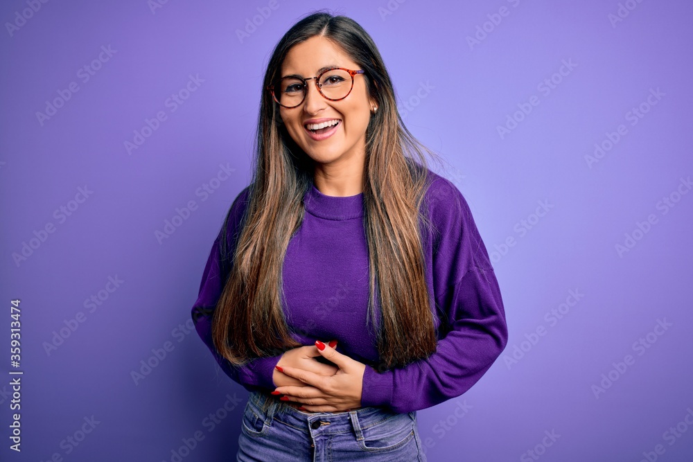 Young beautiful smart woman wearing glasses over purple isolated background smiling and laughing ...
