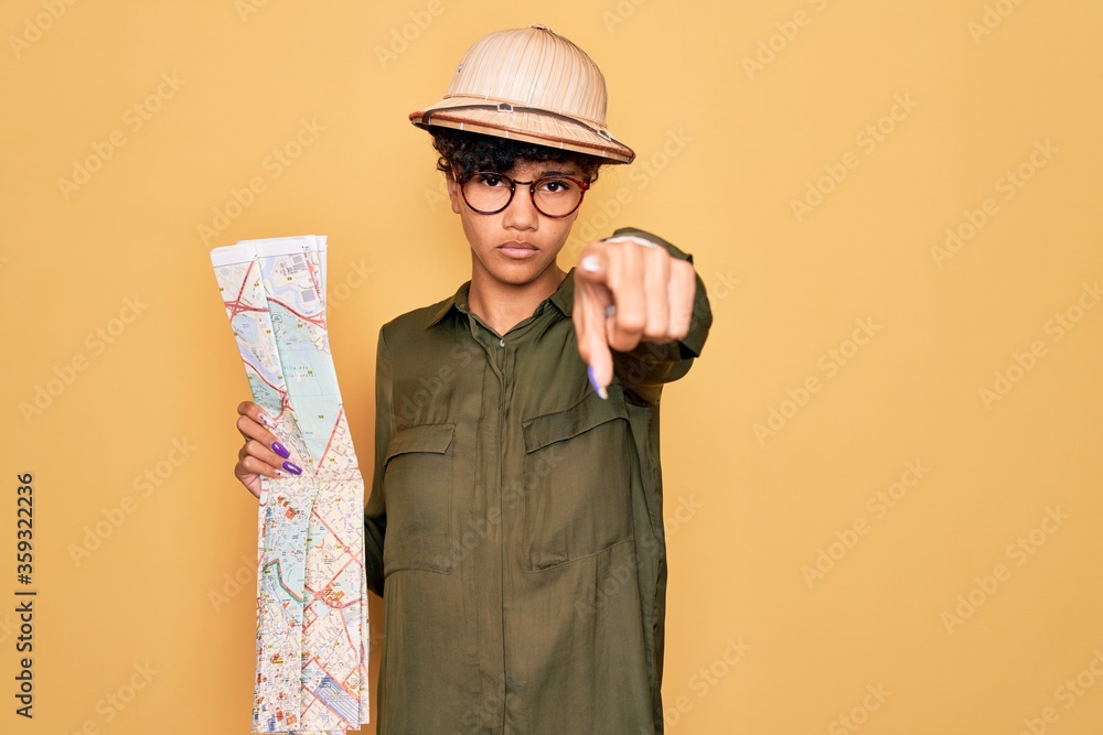Beautiful african american explorer woman wearing hat holding city map ...
