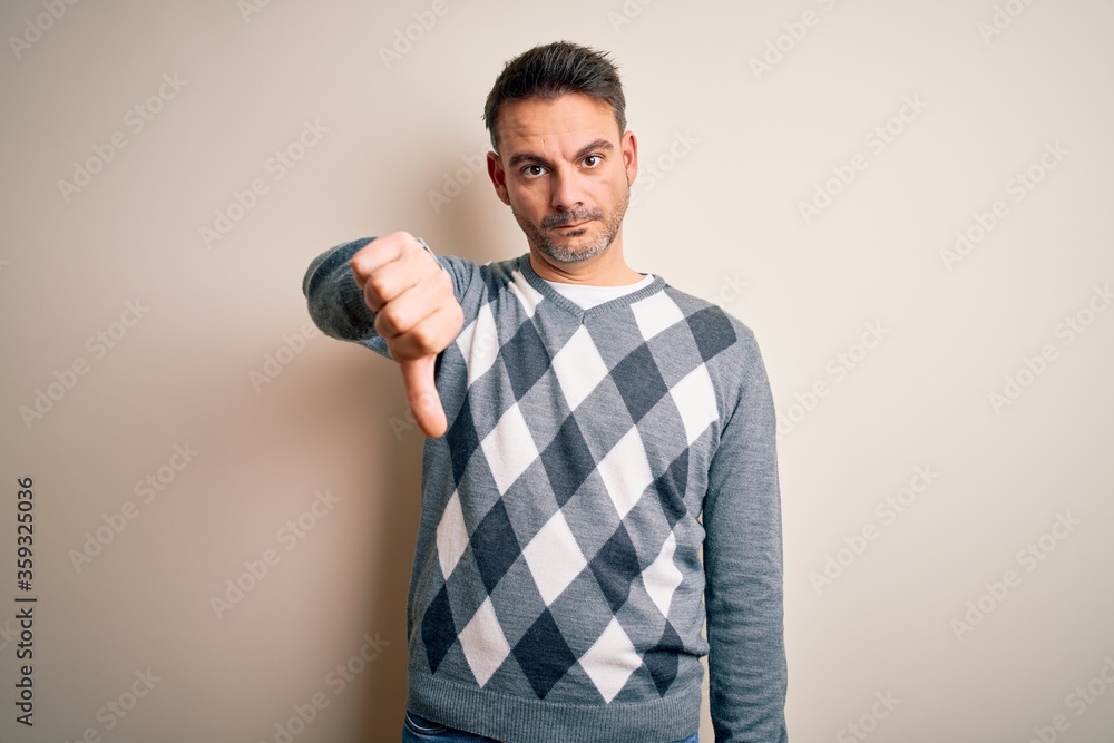 Young handsome man wearing casual sweater standing over isolated white ...