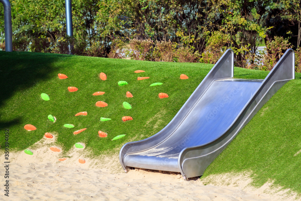 modern playground with a metal slide inscribed in the landscape design ...