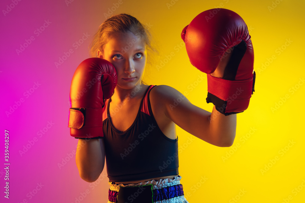 Close up little girl, kick boxer on gradient background in neon light ...