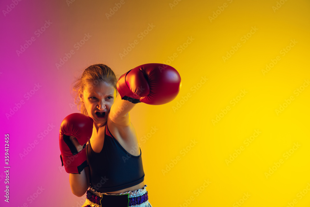 Close up little girl, kick boxer on gradient background in neon light ...