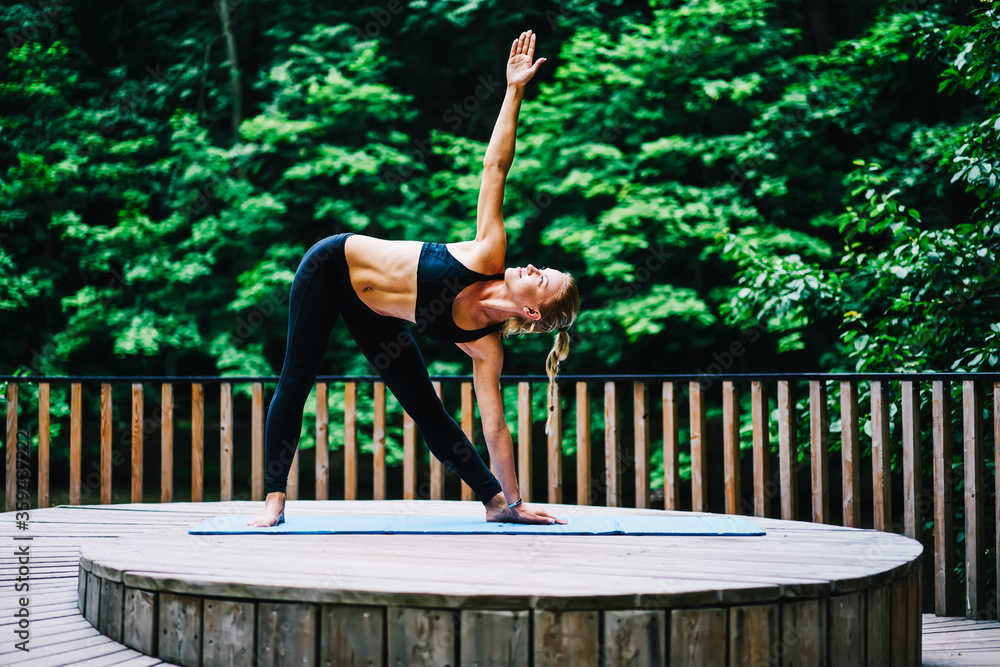 Vigorous sport young woman in stylish comfortable wear raising hand ...