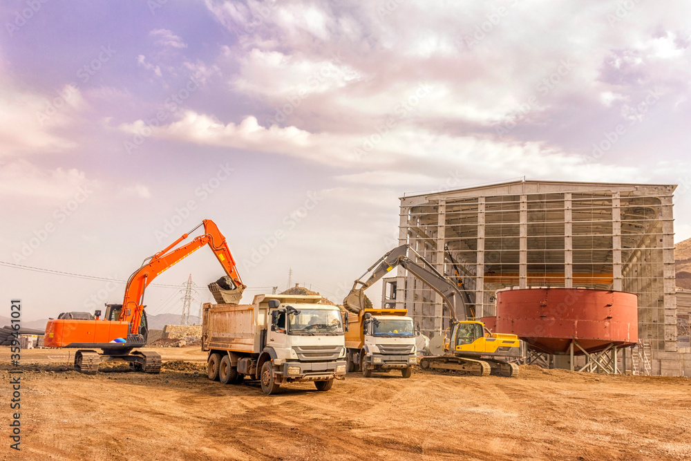 Two excavators are digging and loading the excavation to two trucks in ...