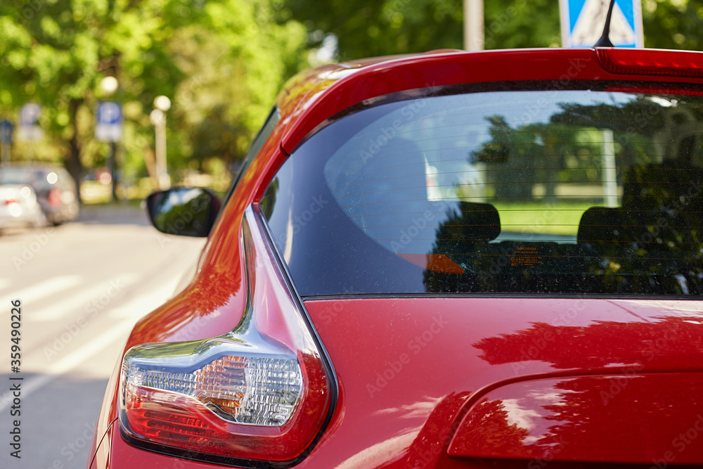 Back window of red car parked on the street in summer sunny day, rear ...