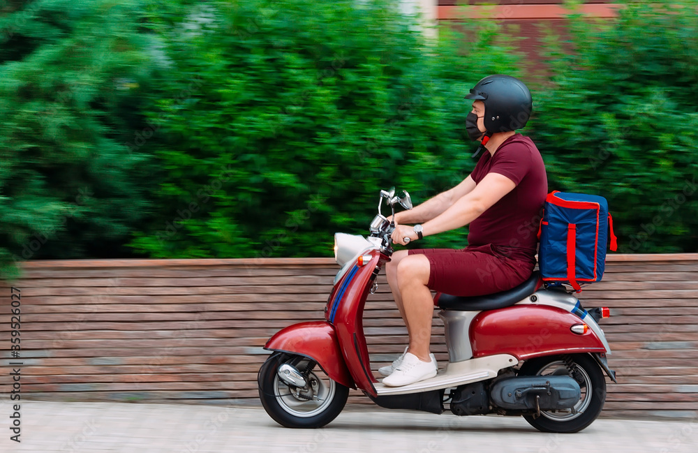 Delivery boy wearing red uniform on scooter with isothermal food case ...