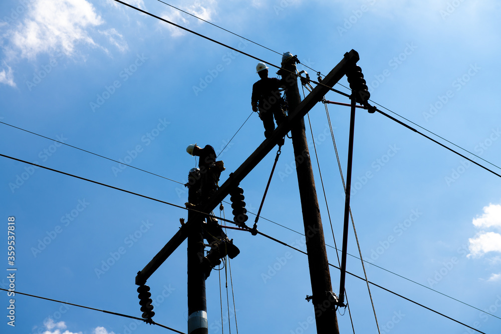 high voltage power lines with silhouette of lineman Stock Photo | Adobe ...