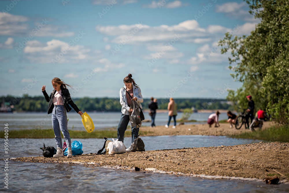 girls with trash on the beach. girls collect garbage on the beach ...