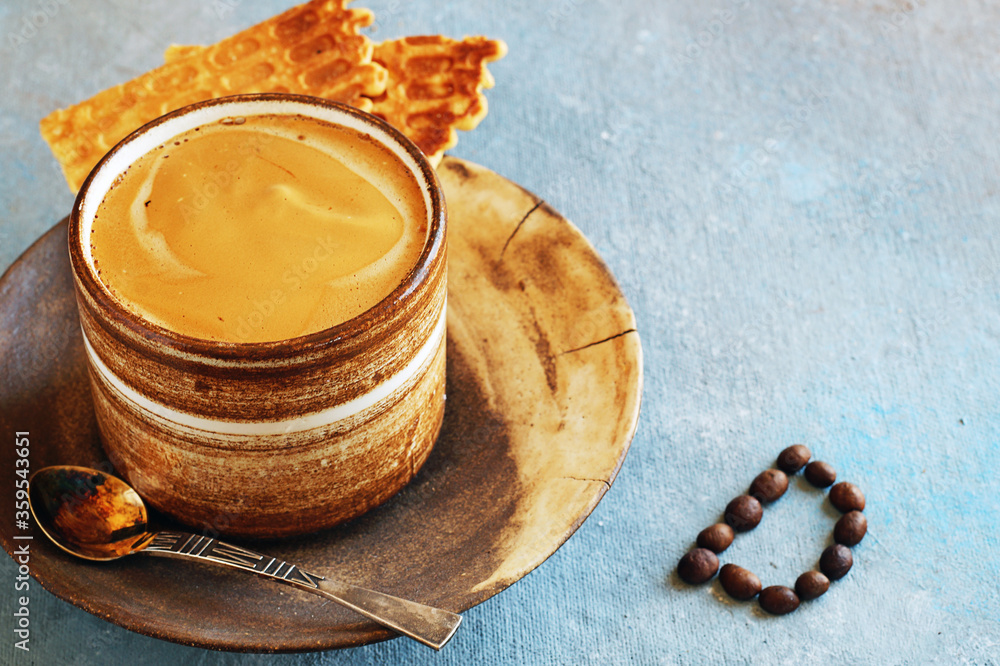 Dalgon coffee in a ceramic Cup, on a plate with homemade waffles and a ...