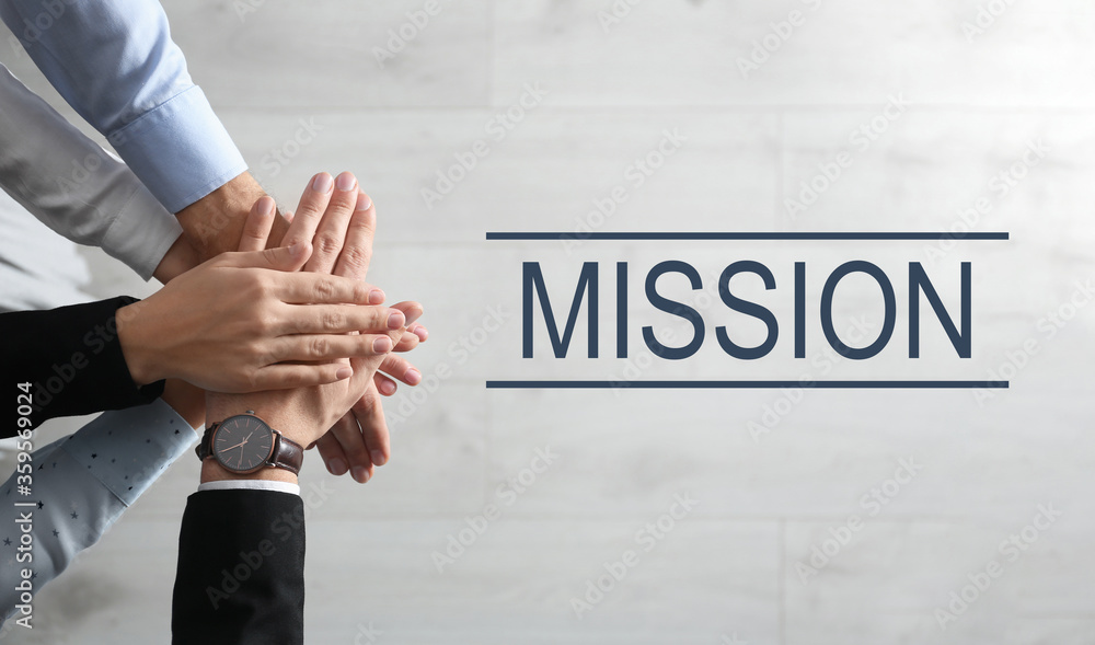 People holding hands together over light wooden background and text ...