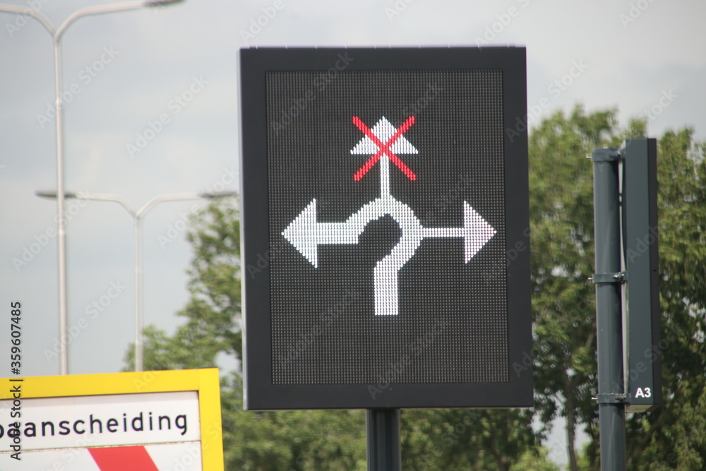 Modern traffic sign with LED lighting indicates the route to the ...