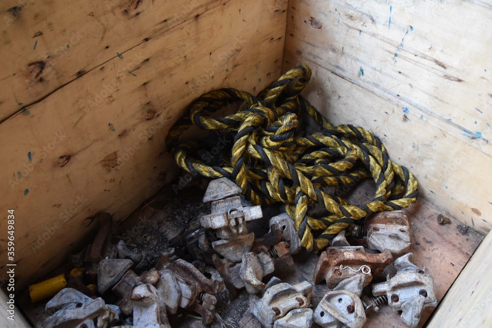 Used, worn and partly rusted twistlocks and cut tiger rope in wooden ...