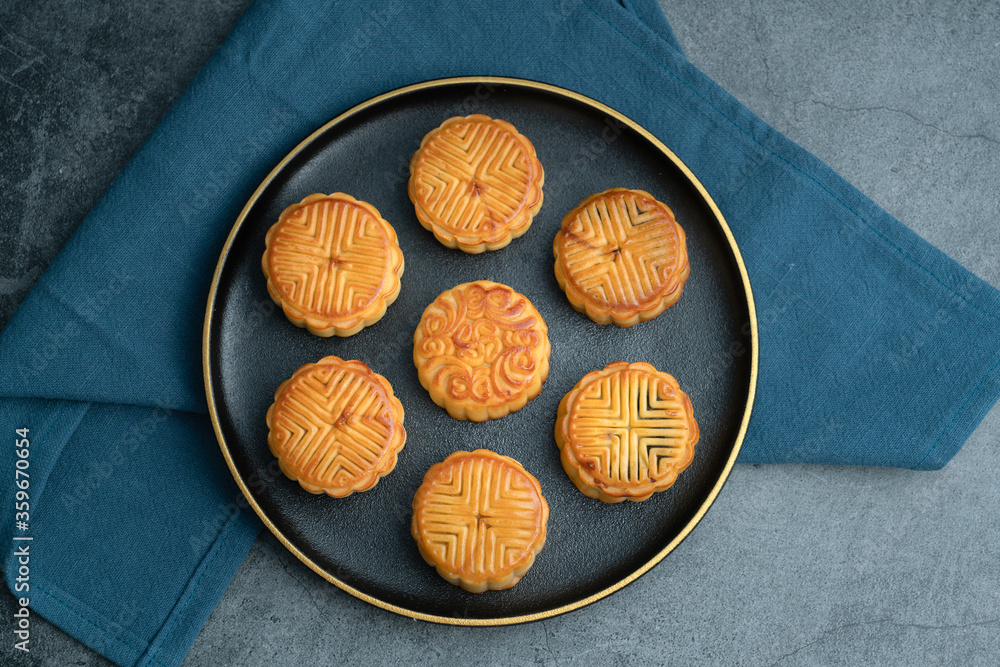 Moon cakes for the Mid-Autumn Festival are placed on a black plate with ...