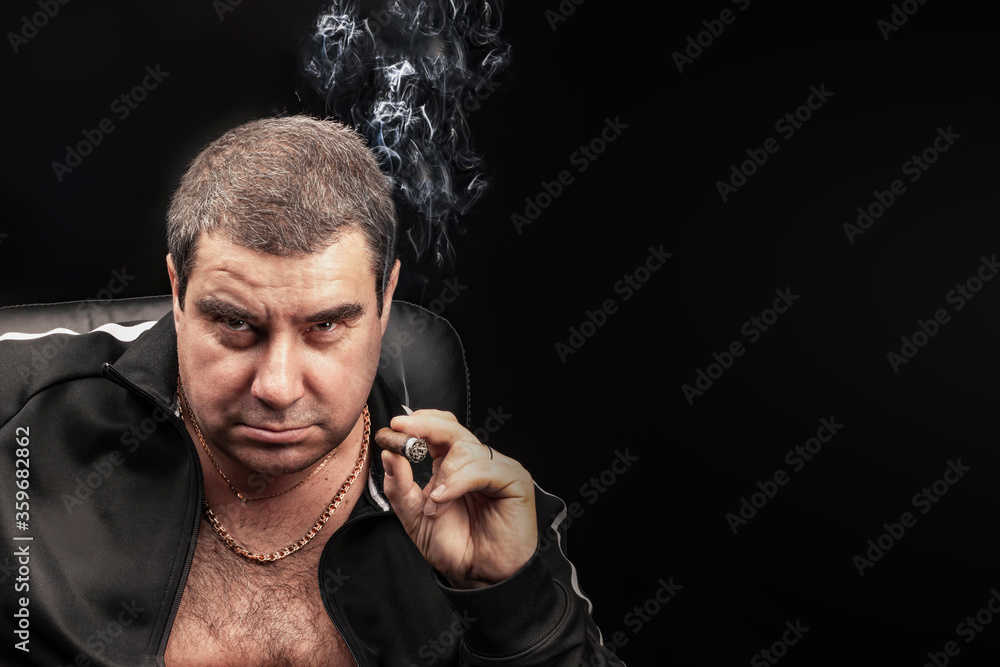 a stern adult man Smoking a cigar looks confidently at the camera. copy ...