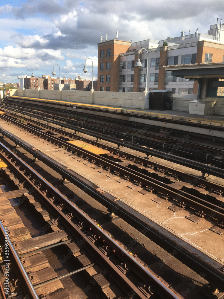 Overground train tracks at an empty subway platform in Queens, NY ...