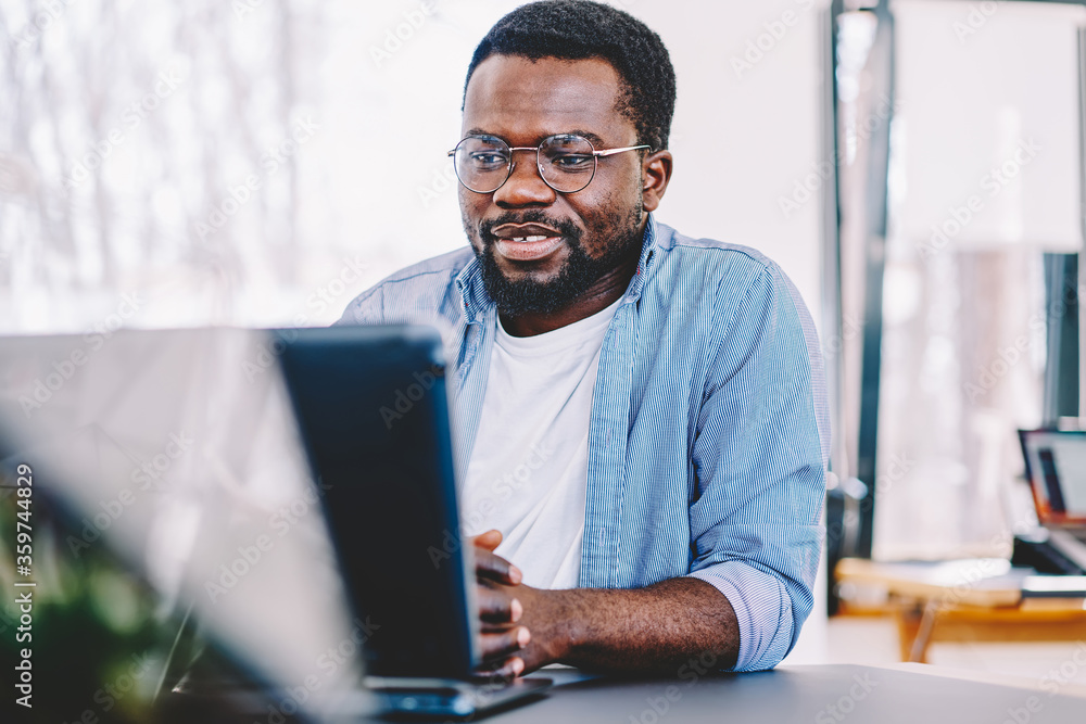 Smart african american dark skinned man watching tutorial on laptop ...