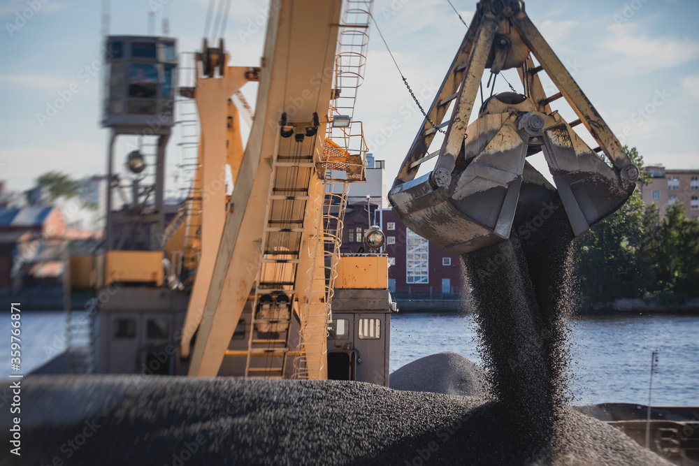 Fotografia do Stock: Bulk-handling crane unloading sand, road metal and ...