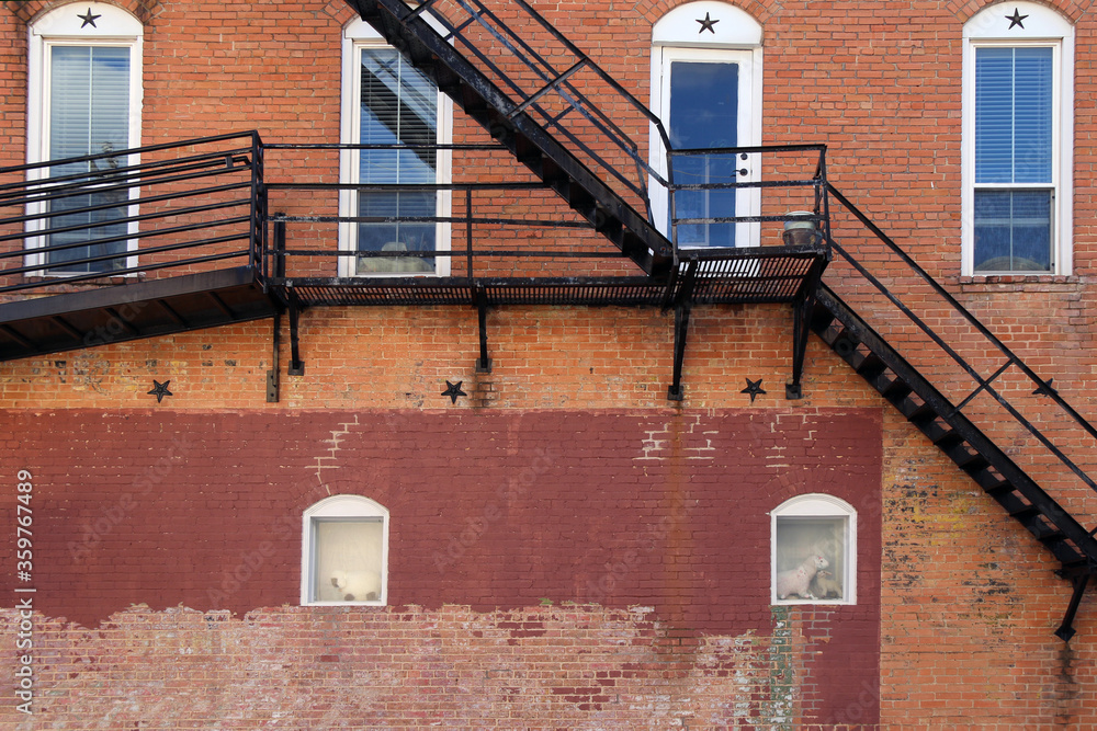 arched white windows behind back alley fire escape stairs at an old ...