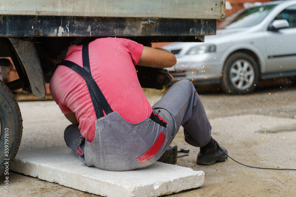 Caucasian man unknown person male adult fixing the back of the truck or ...