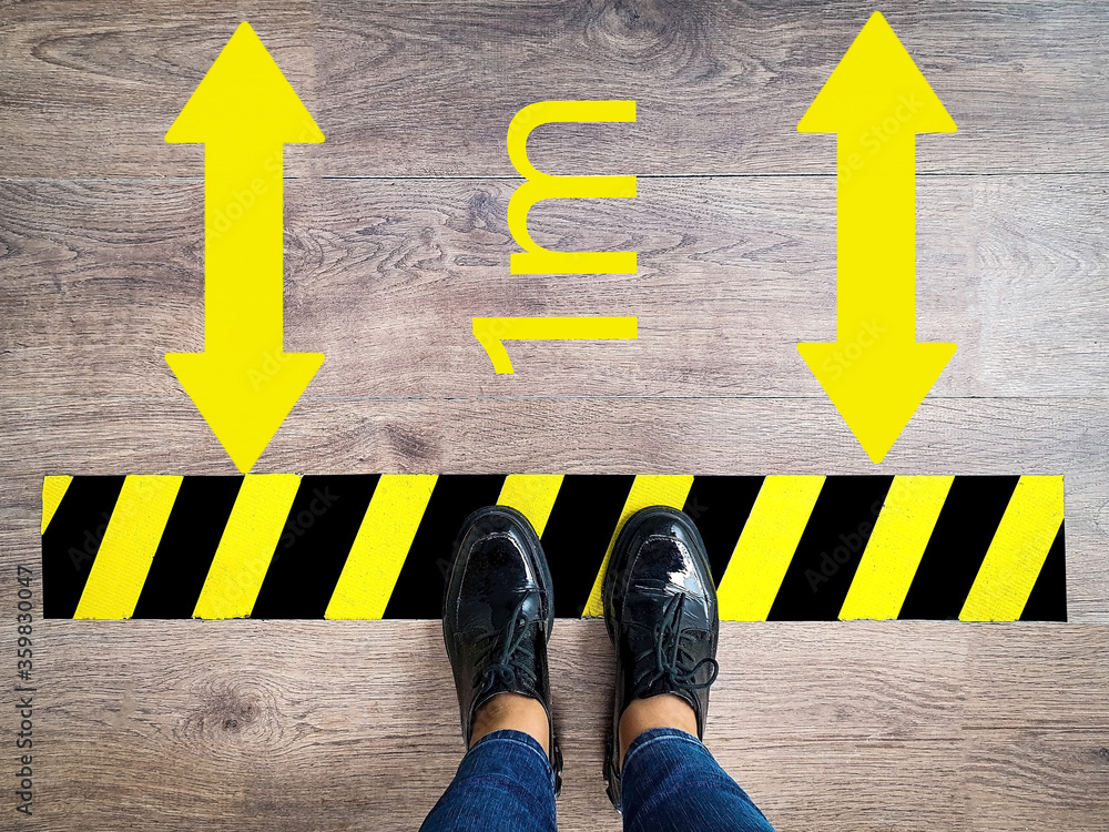 Foto de person stands in line with yellow and black stripes keeping ...