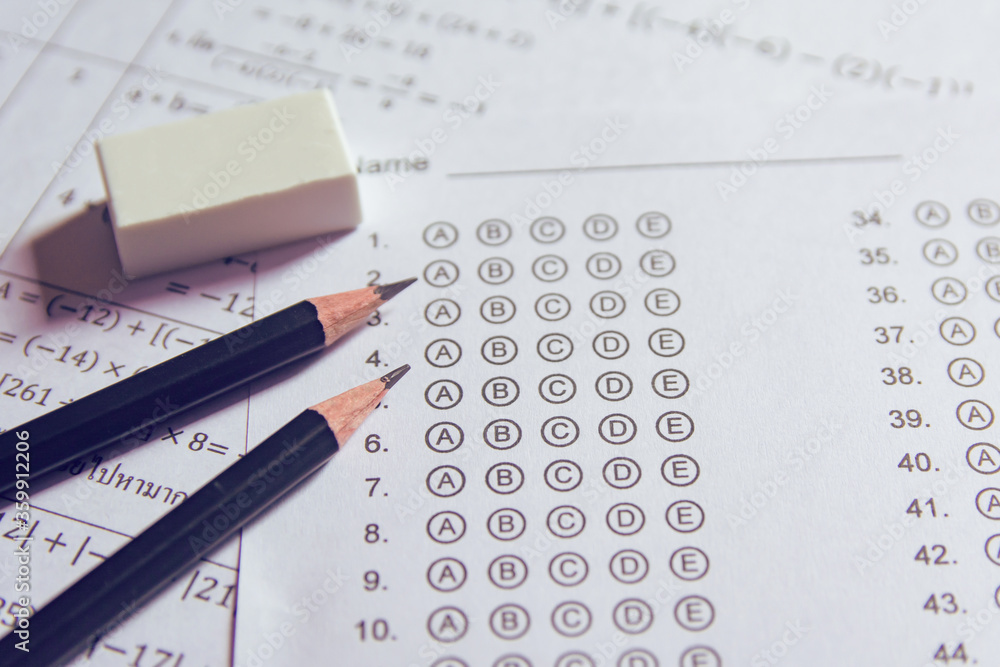 Pencil and eraser on answer sheets or Standardized test form with ...