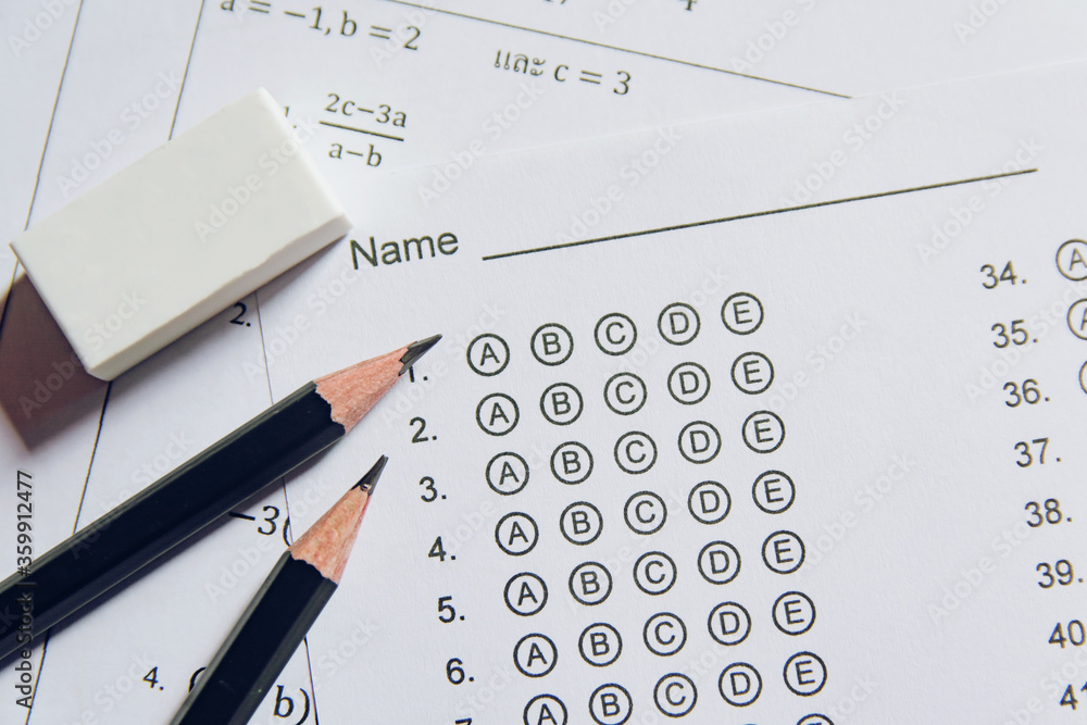 Pencil and eraser on answer sheets or Standardized test form with ...