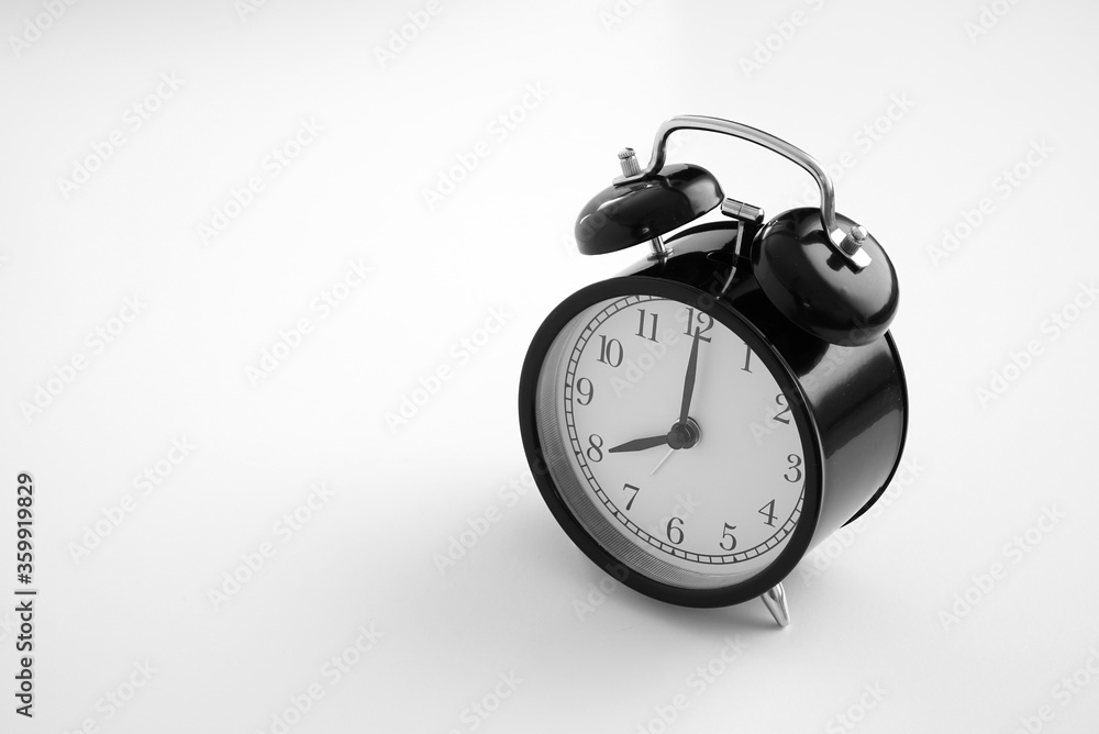 Black vintage alarm clock on table. White background. Wake up concept ...