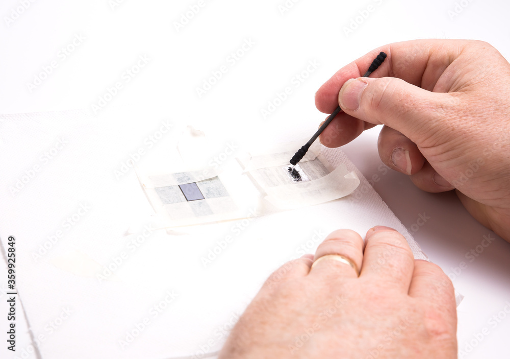 Man applying liquid metal to the back of a cpu computer processor unit ...
