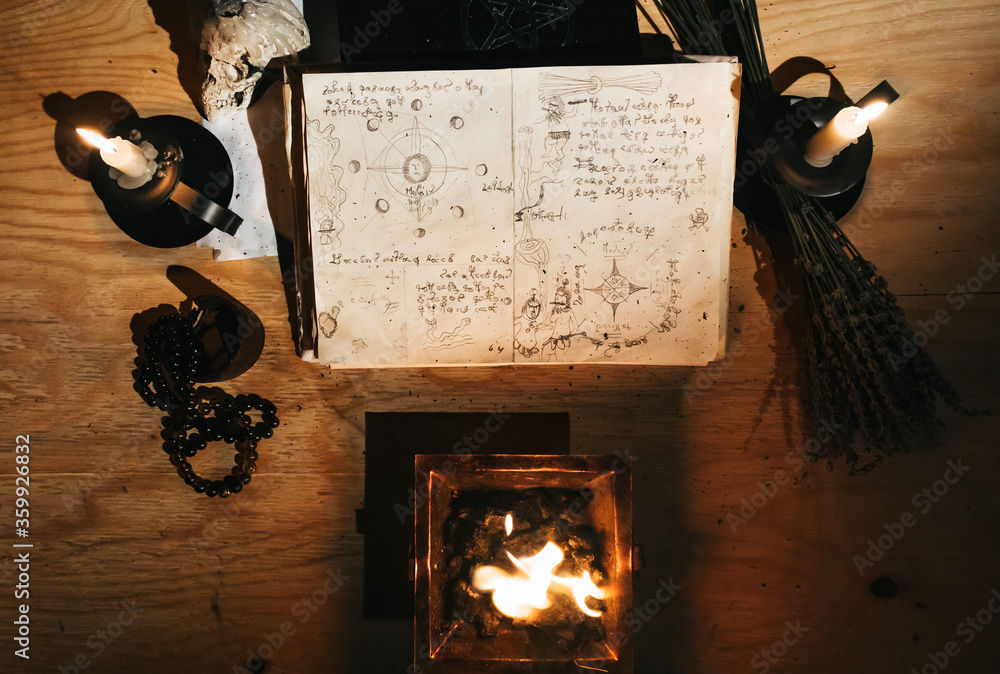 Occult white magic ritual of fire using grimoire, old book, candles ...